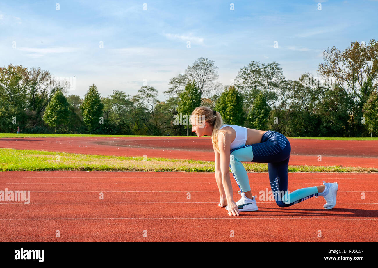 Beautiful woman ready to start running on runway Stock Photo - Alamy