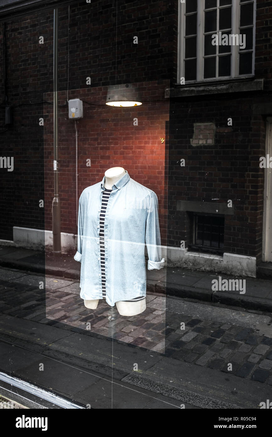 Shirt displayed in a shop window with reflections of the outside street ...