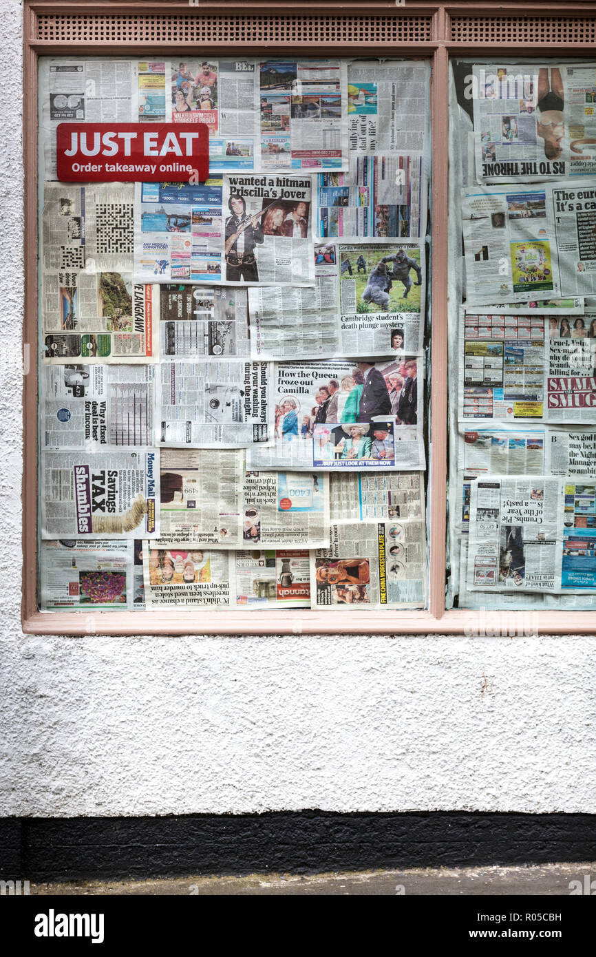 Shop window covered on the inside with newpaper pages Stock Photo - Alamy