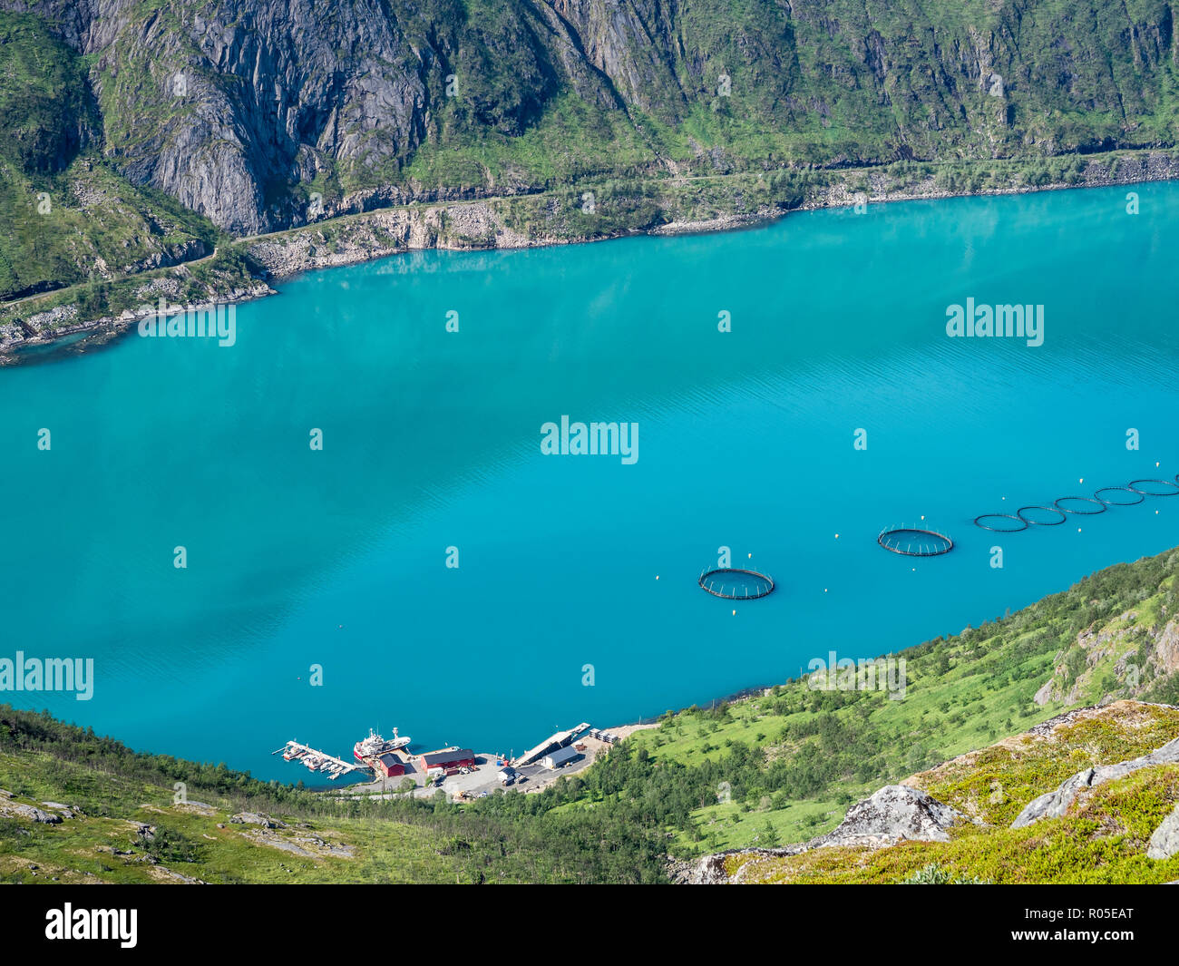 View over fjord Örnfjord, cages of salmon farm in the fjord, road along ...