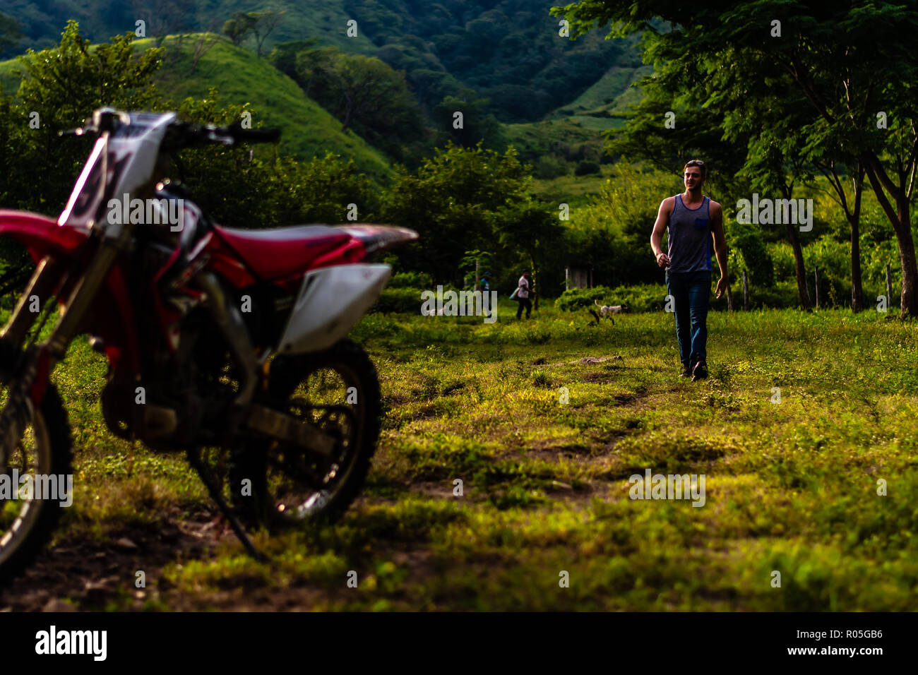 man walking away from dirt bike motorcycle Stock Photo - Alamy