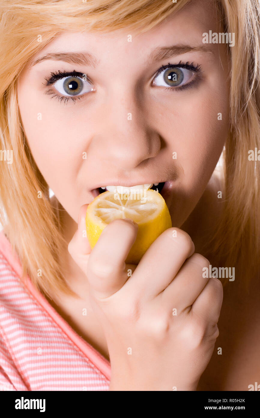 beautiful young girl eating lemon closeup on white background Stock ...