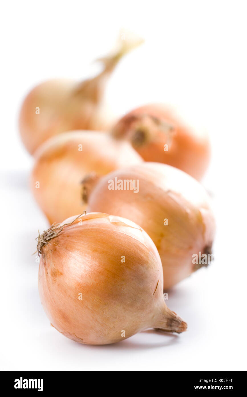 five ripe onions on a white background Stock Photo - Alamy
