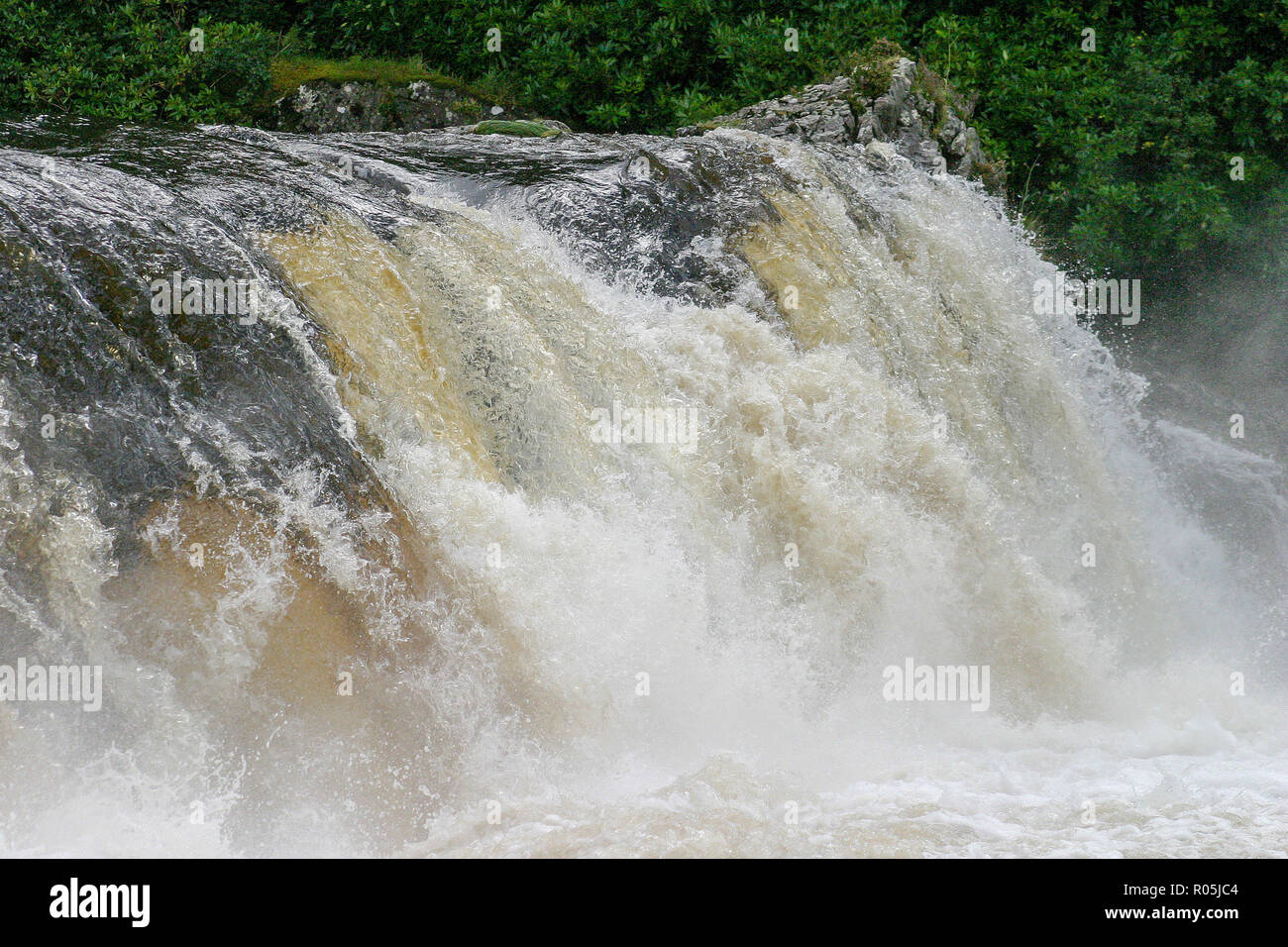 Peat-coloured water flowing over a waterfall - Aasleagh Falls ...