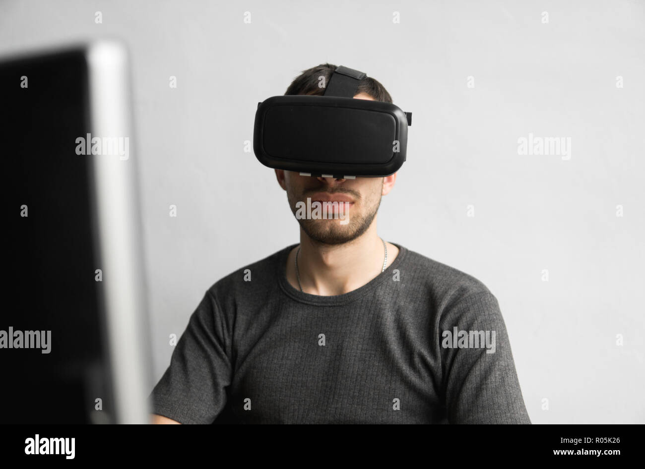 Young man wearing virtual reality goggles headset, vr box and sitting ...