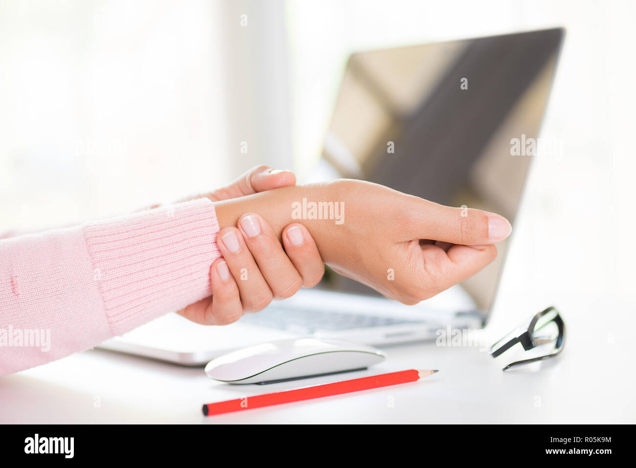 Closeup woman holding her wrist pain from using computer. Office ...