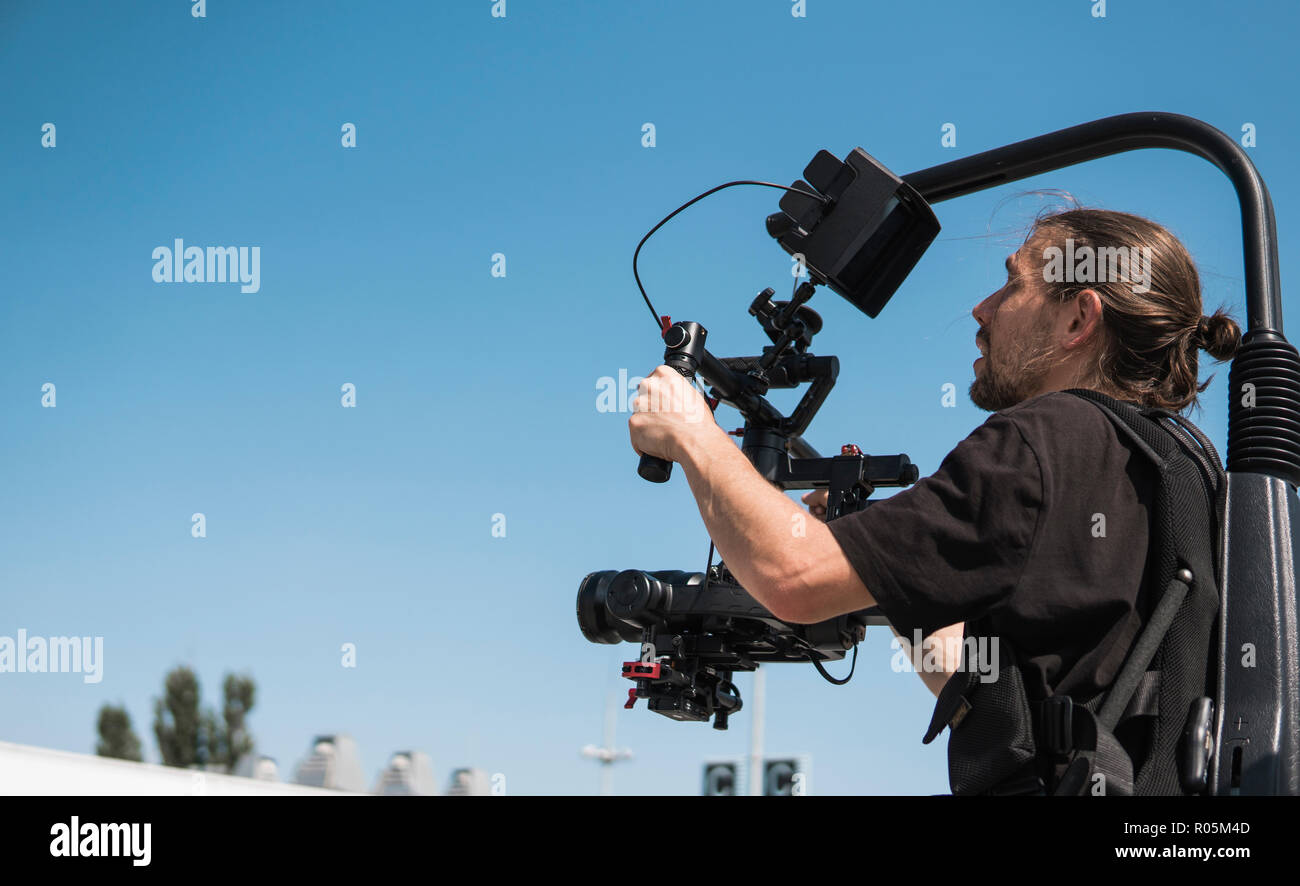 Professional videographer holding camera on 3-axis gimbal which mounted ...