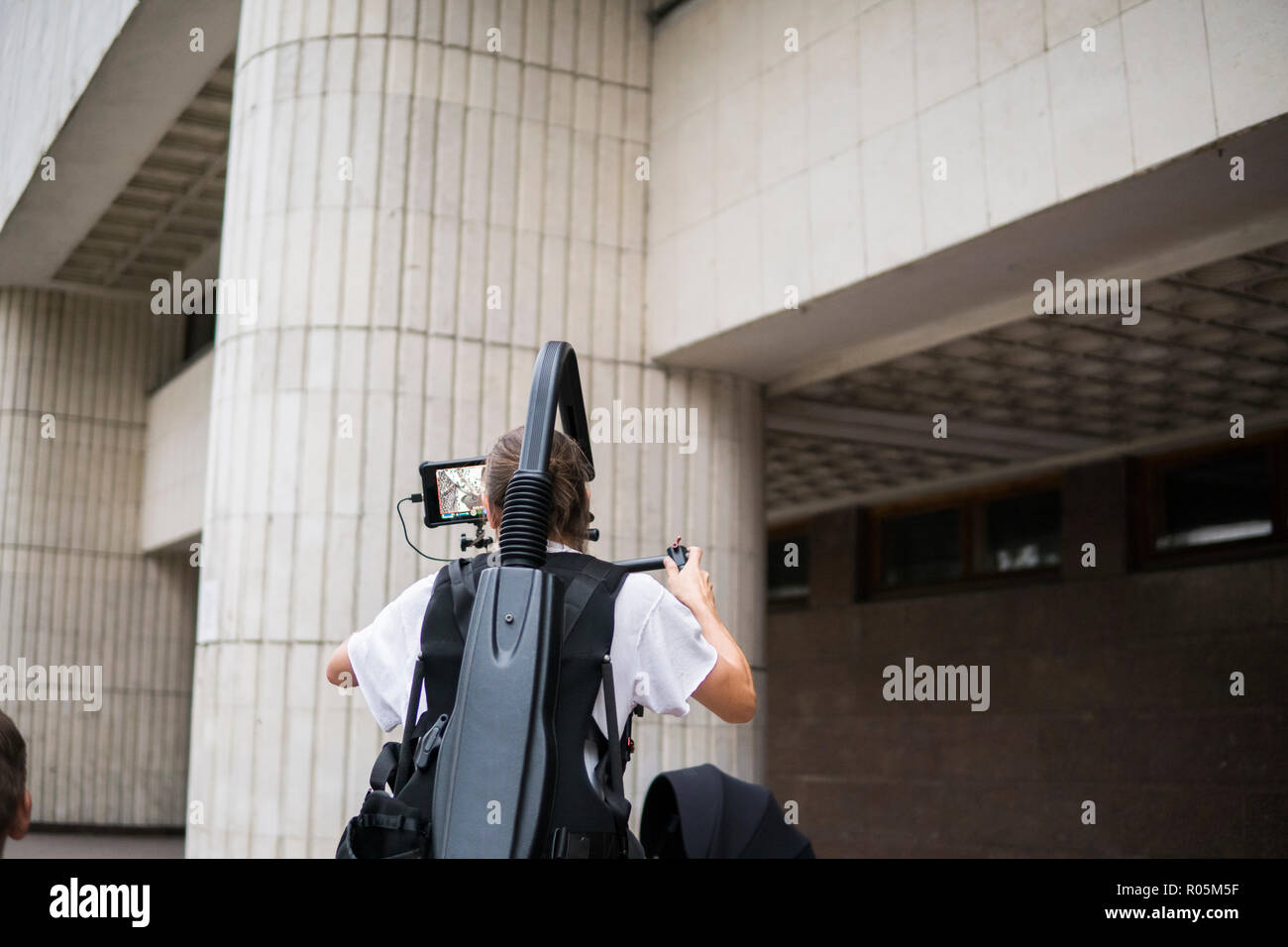 Professional videographer holding camera on 3-axis gimbal which mounted ...