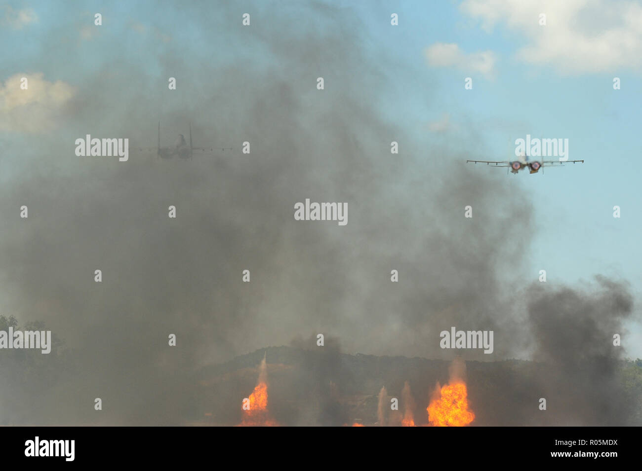Two jet fighter aircarft seen in between smoke and fire after bombing ...