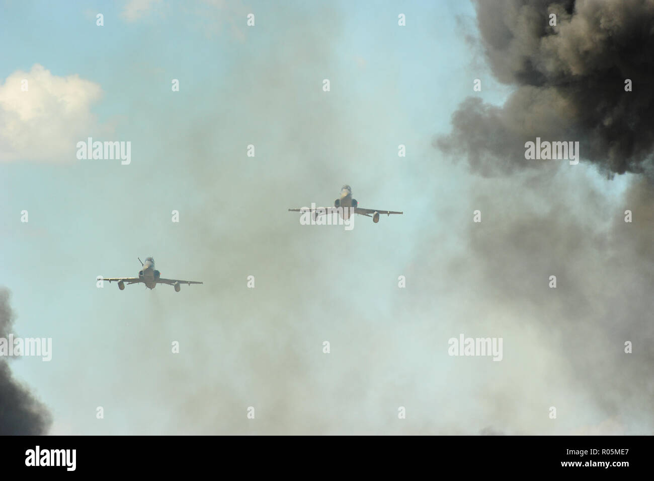 Two jet fighter aircarft seen in between smoke and fire after bombing ...