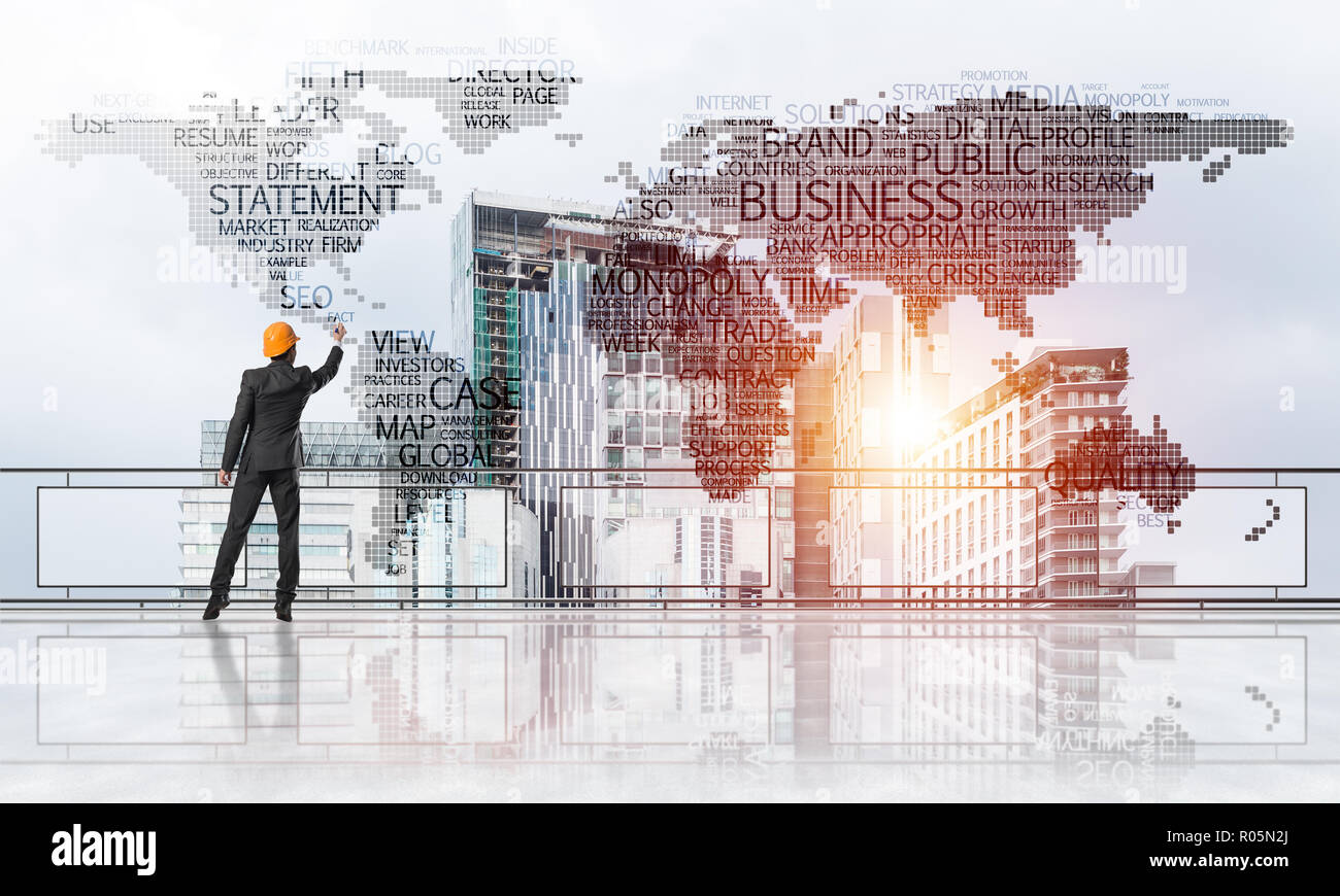 Sunrise above skyscrapers and engineer in helmet drawing globalization ...