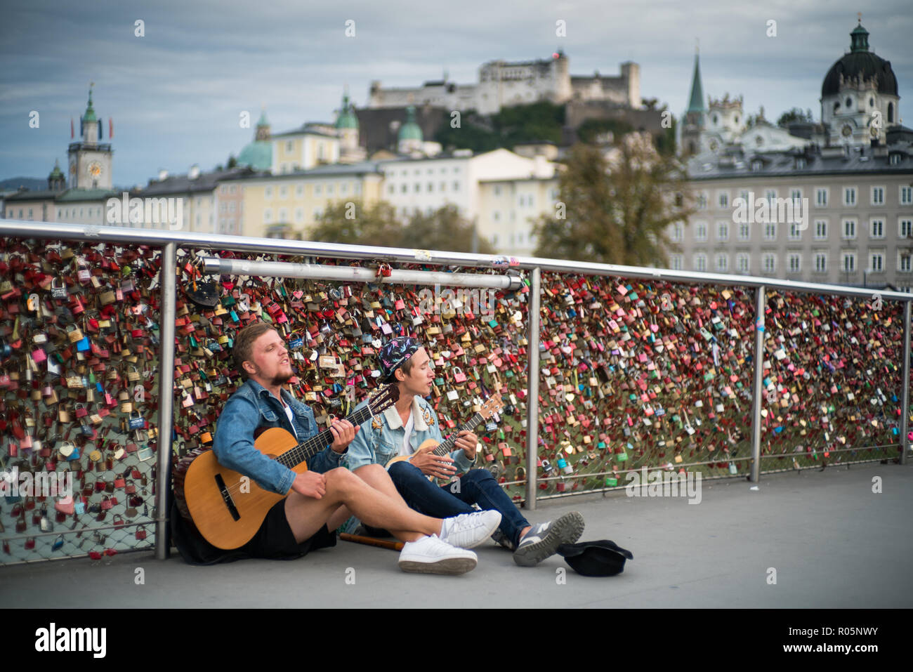 Two young man play on guitar on the bridge in the Salzburg, Austria ...