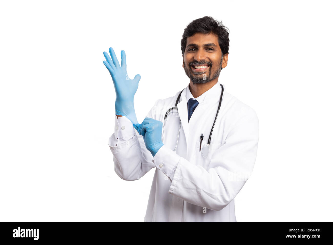 Trustworthy indian medic man putting on blue surgical latex glove with ...