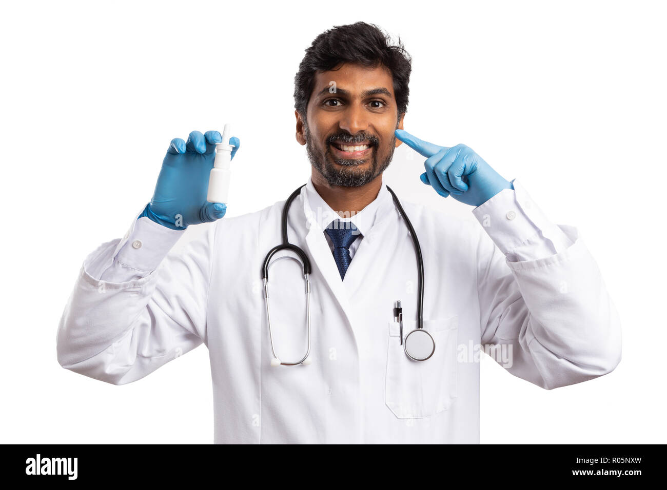 Smiling indian physician or medic presenting nasal spray and pointing ...