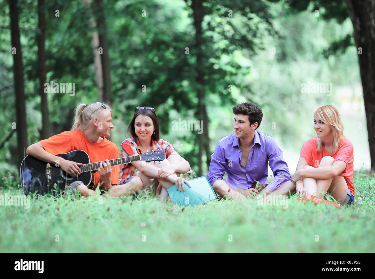 group of students sing songs sitting on the lawn in the city Park Stock ...