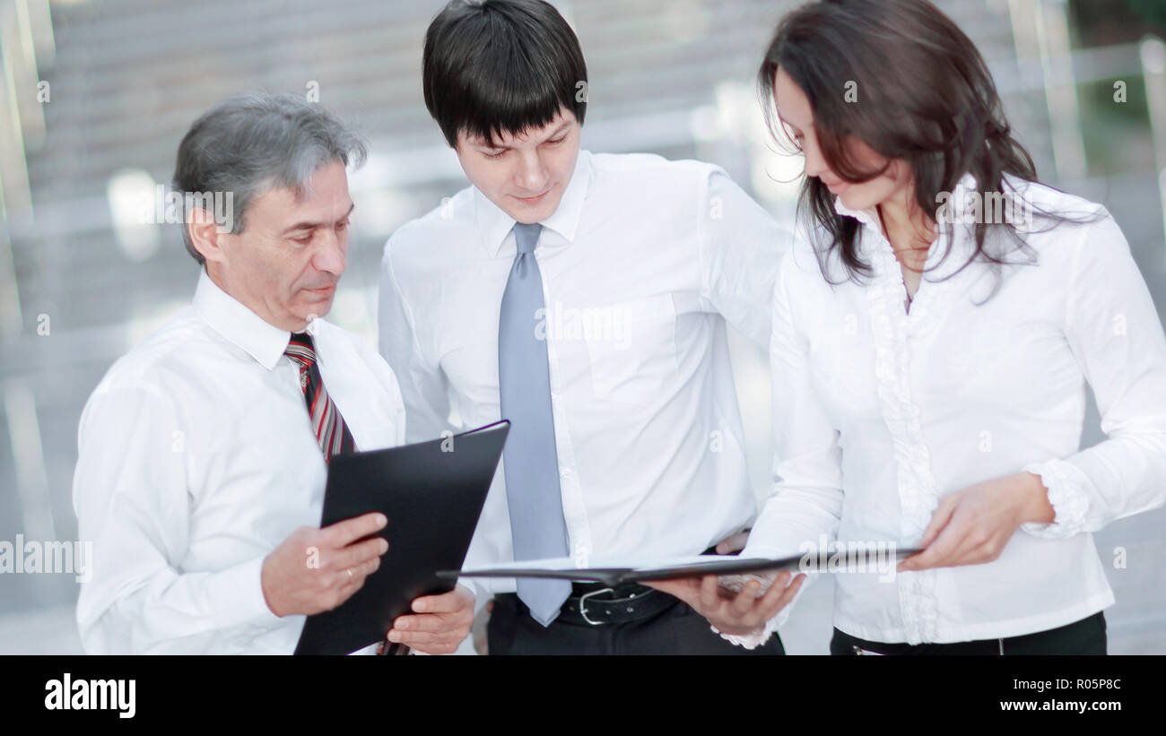 business colleagues discussing working papers standing in a modern ...