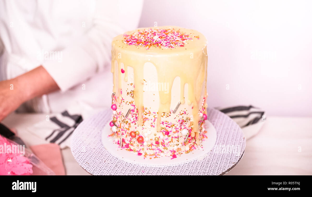 Step by step. Decorating tall birthday cake with a pink sprinkles Stock ...
