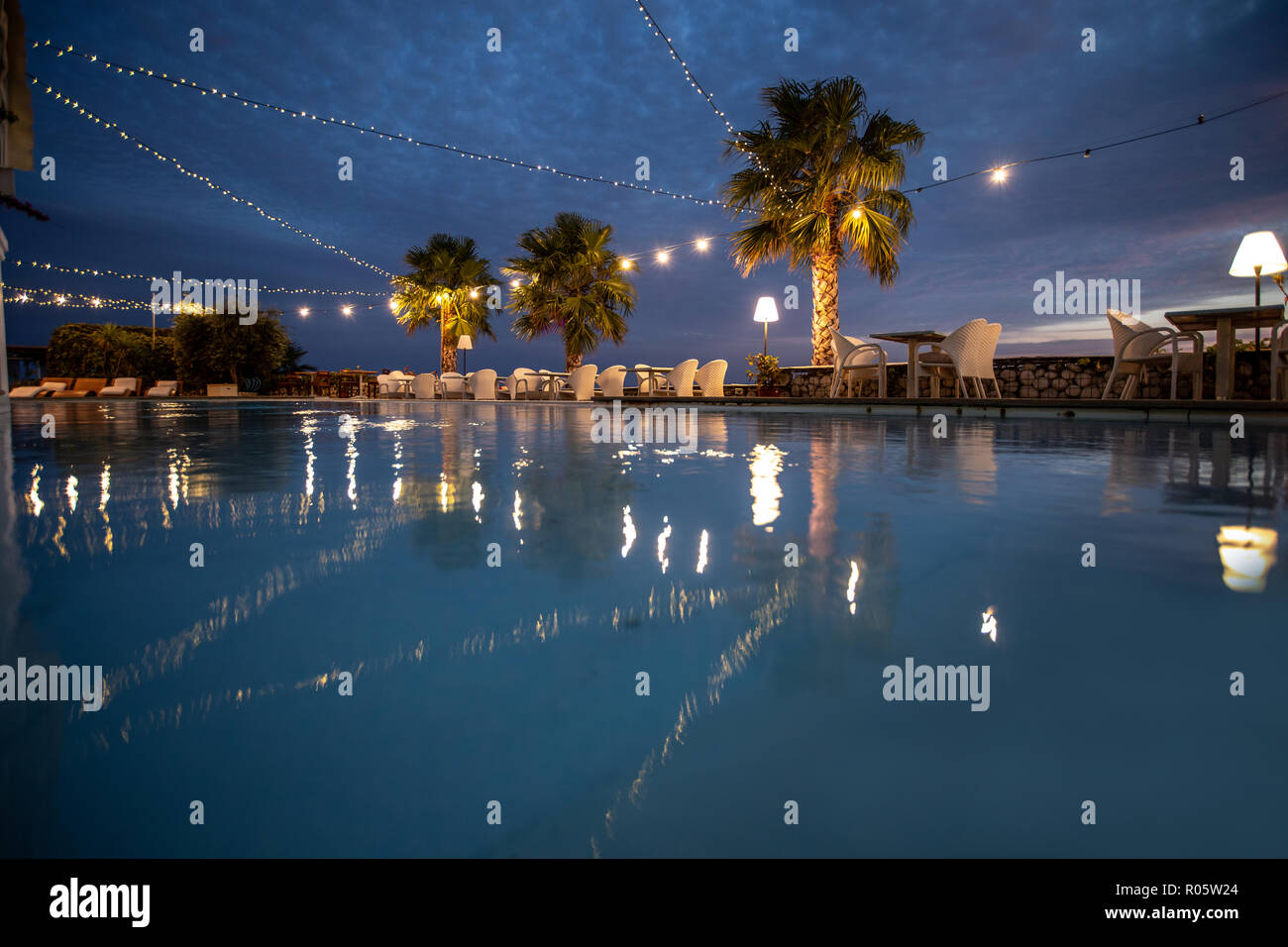 Romantic restaurant by the pool at night. Reflection in water Stock ...