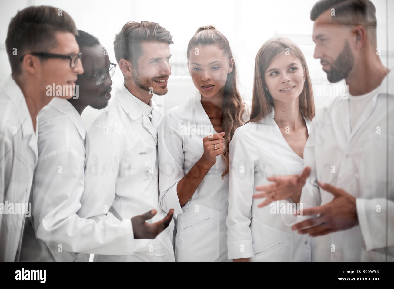 group of laboratory scientists discussing their research in the ...