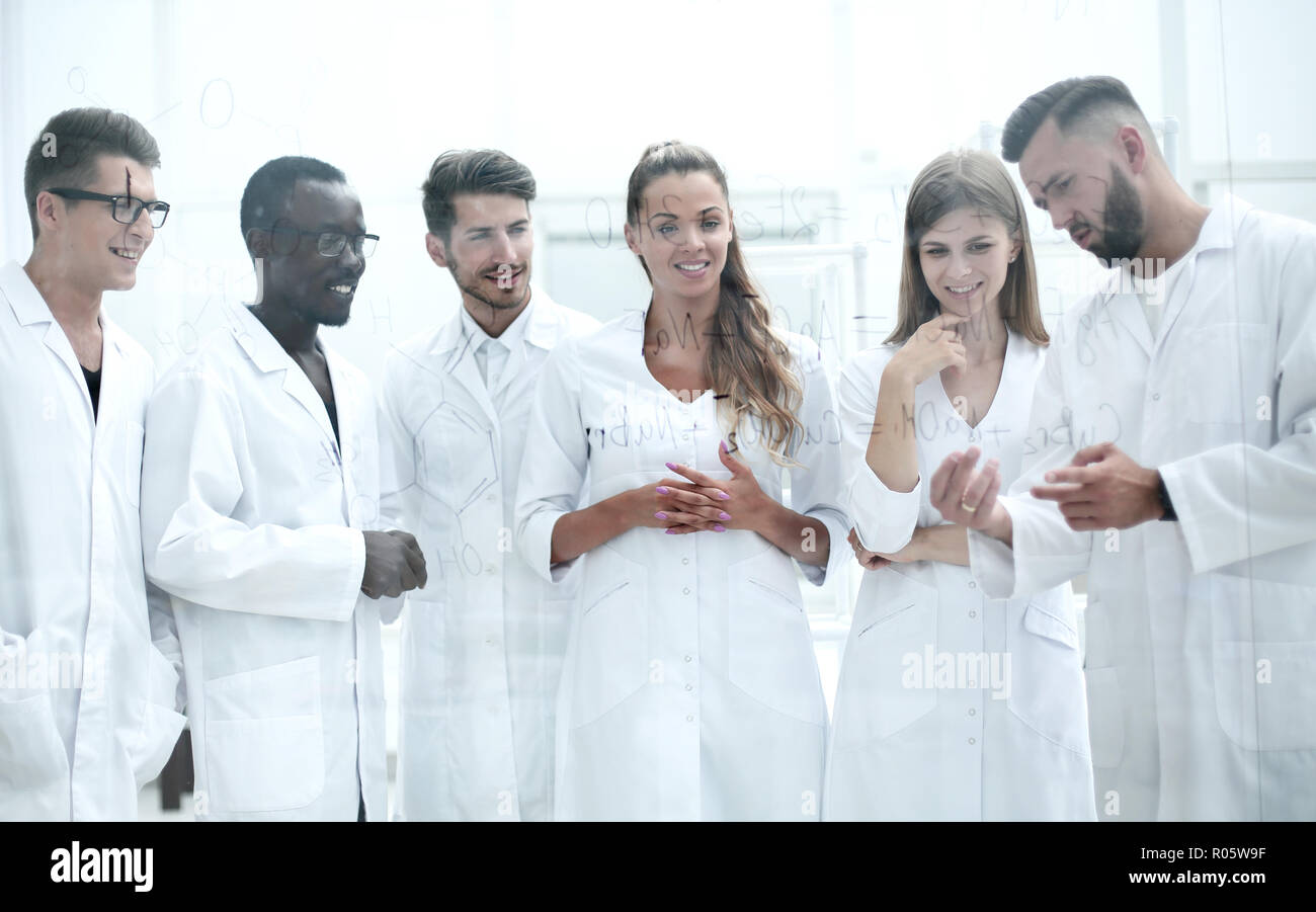 group of laboratory scientists discussing their research in the ...