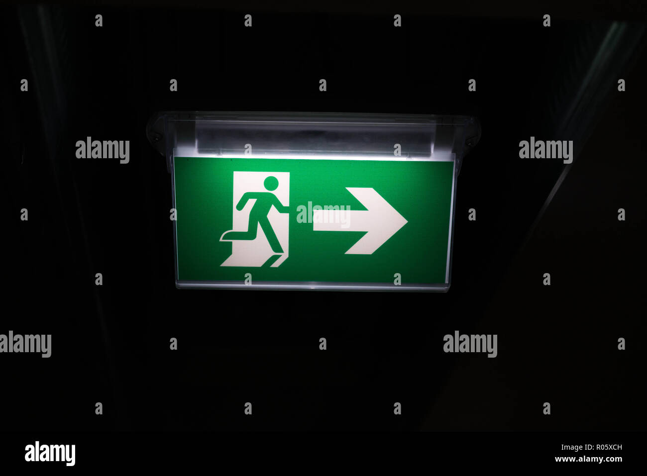 Emergency exit sign in dark parking garage Stock Photo - Alamy
