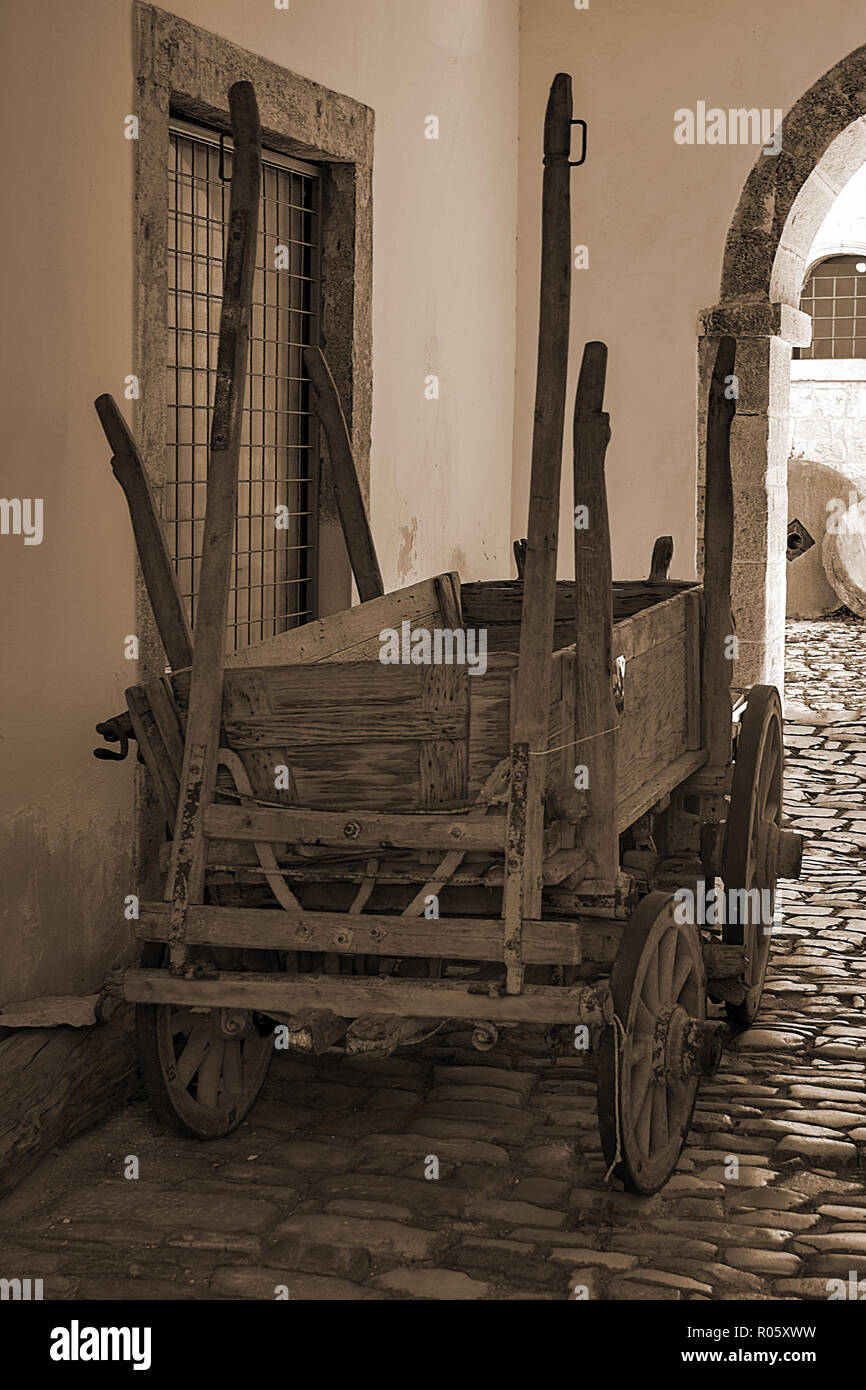 An old carriage that binds to a horse. The plow and blade are loaded on ...