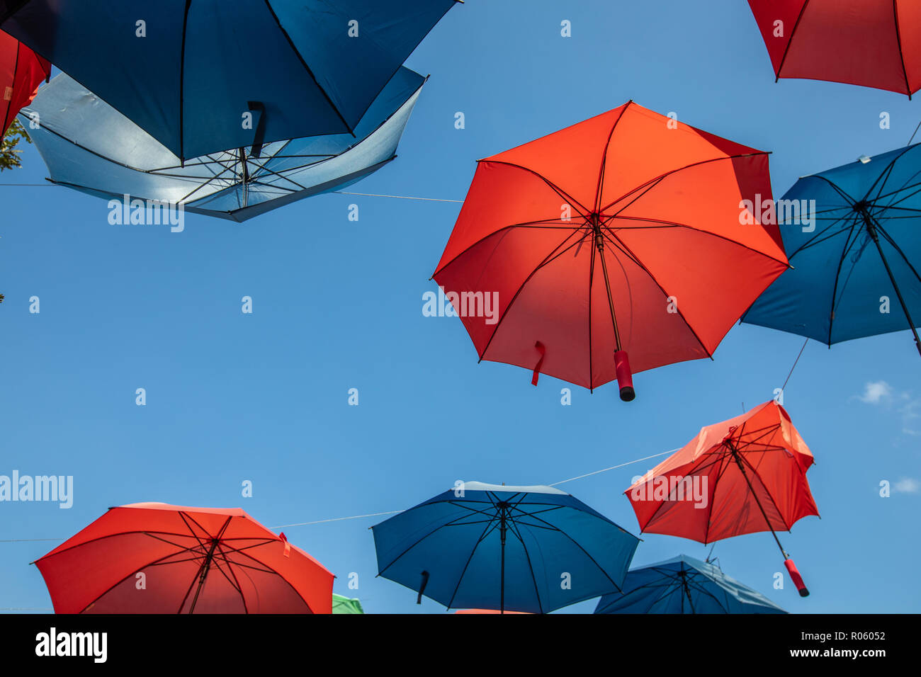 Colored umbrellas on the blue sky background on the street Stock Photo ...