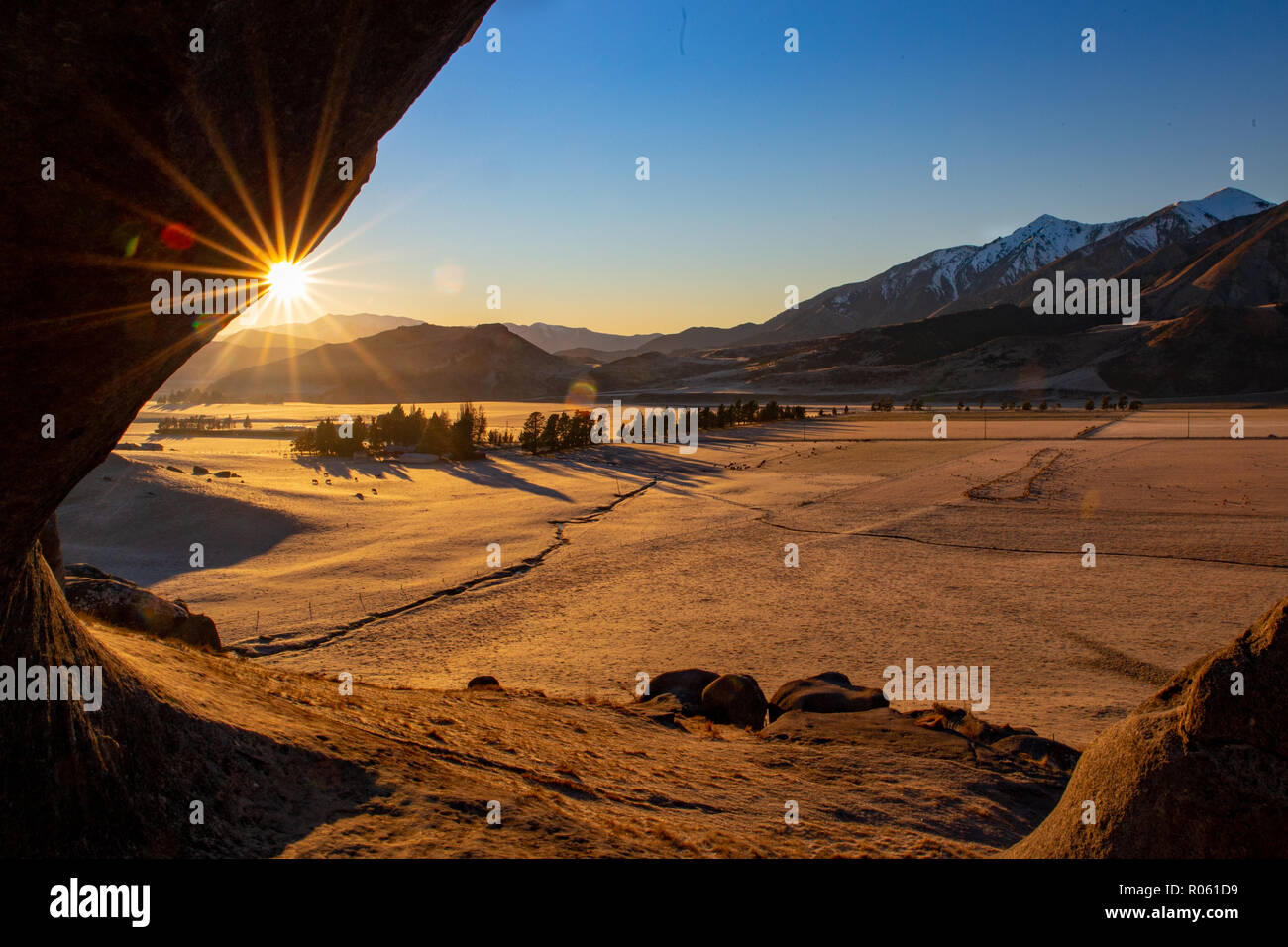 The sun rises over the mountain range to cast a golden glow over the ...