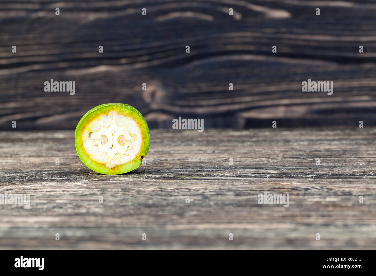 one walnut kernel cut in half, on a wooden table, the walnut structure ...