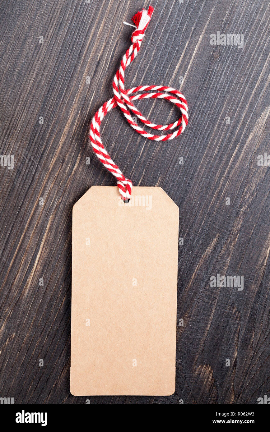 Recycled paper tag with a red and white rope on a black board ...