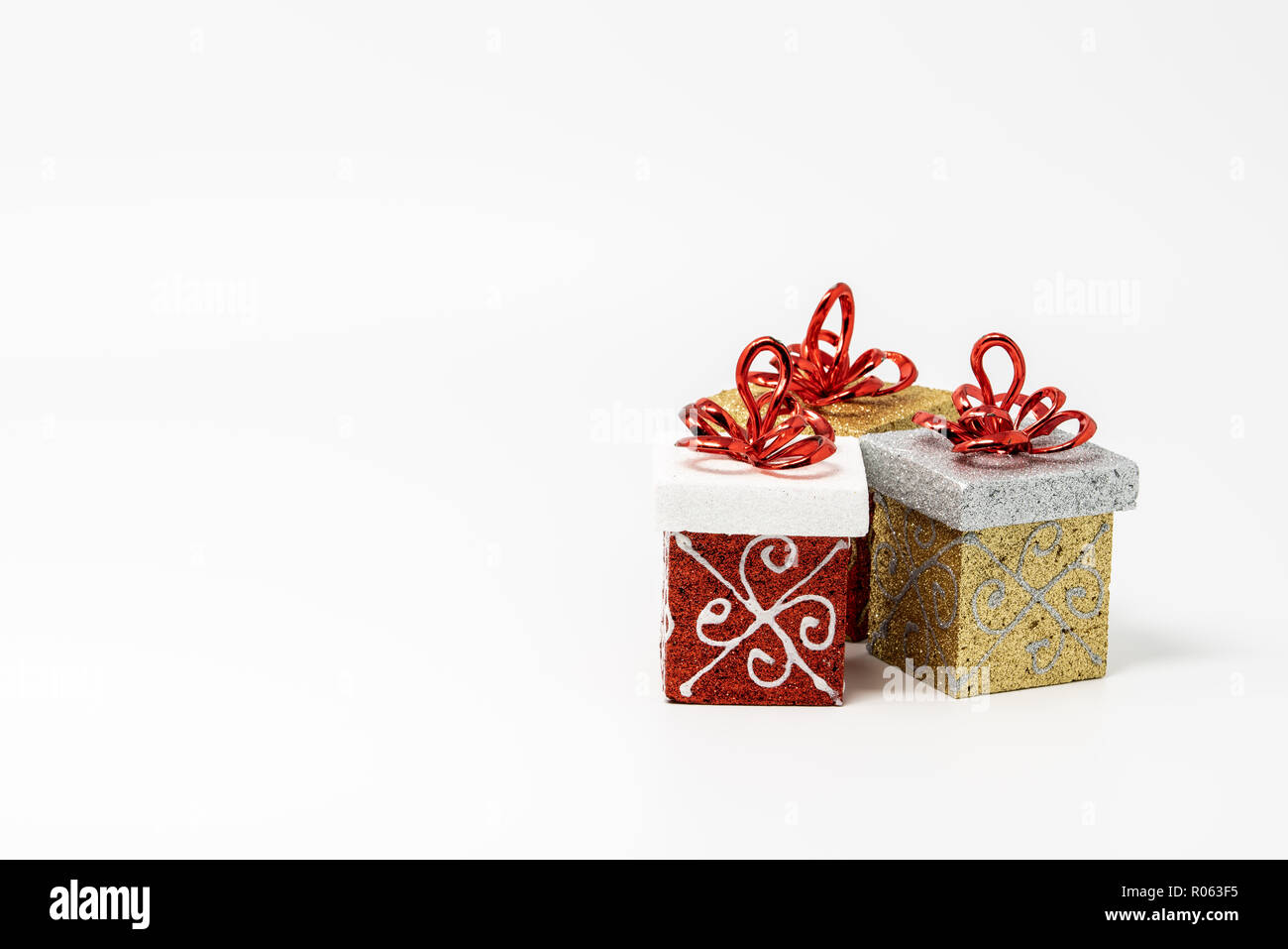Three colored winter festive boxes as decorations, isolated on white ...