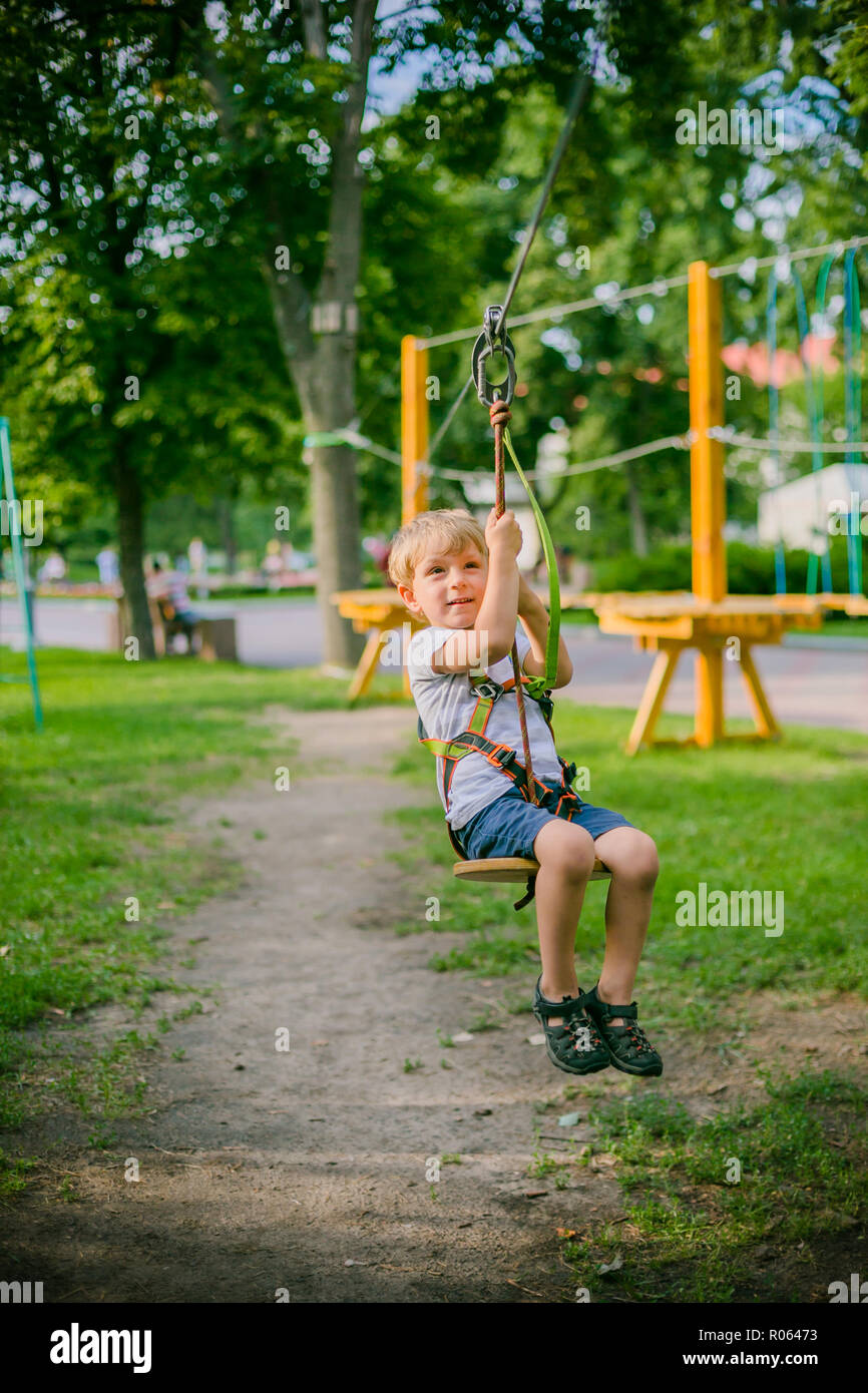 Boy climbing pass obstacles in rope park, fun activity Stock Photo - Alamy