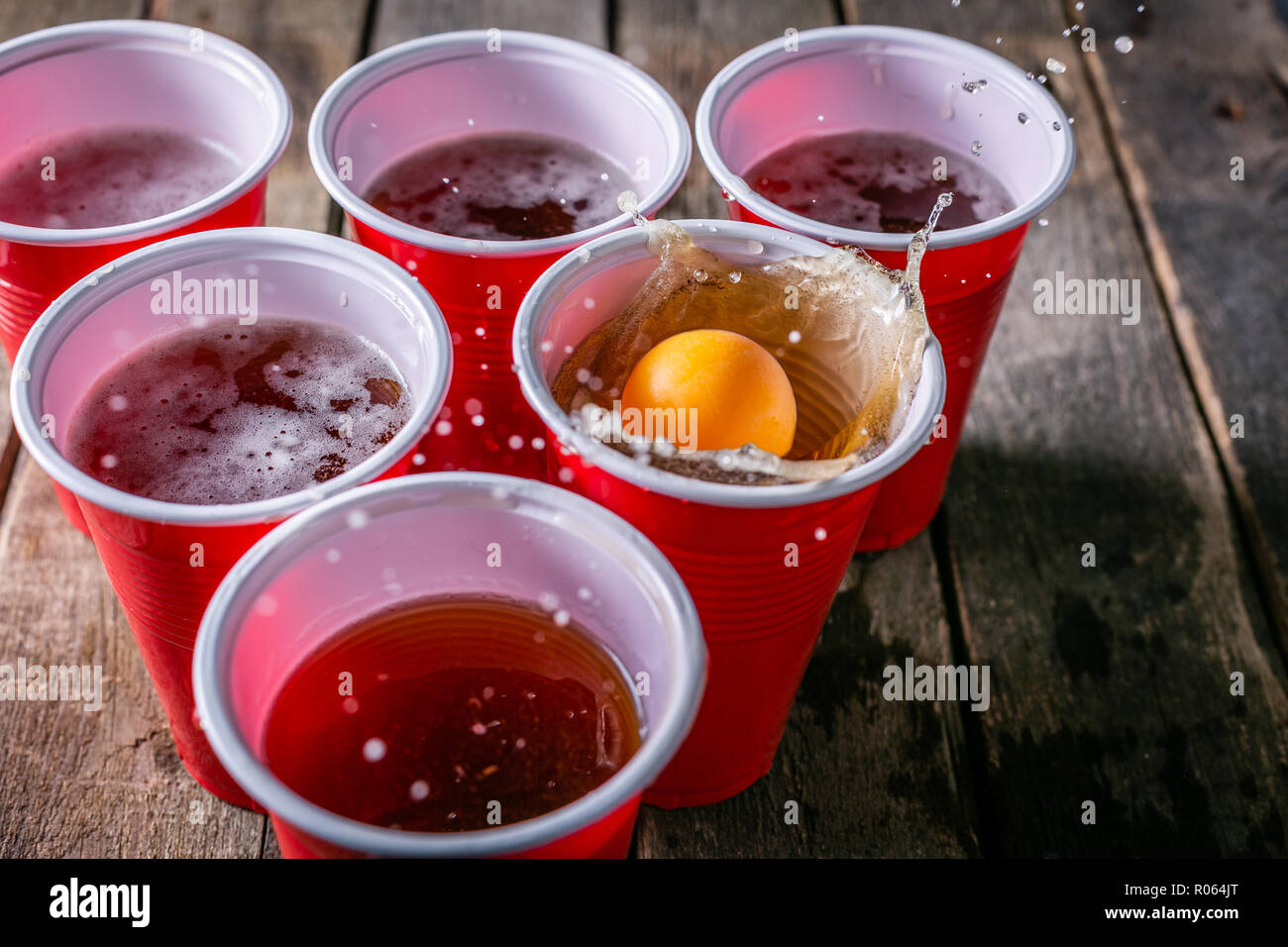 College party sport - beer pong table setting with plastic cups, rustic ...
