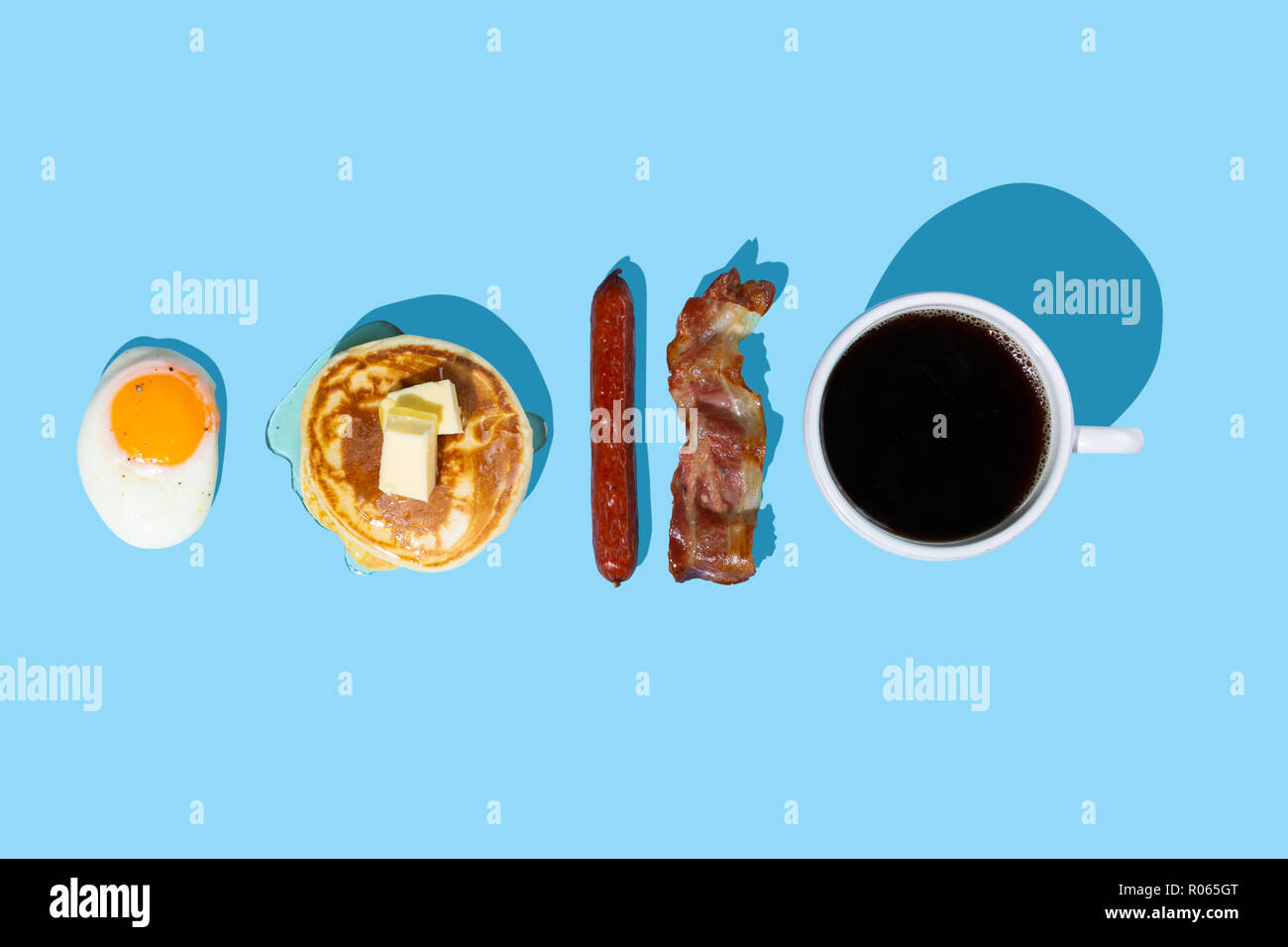 Creative layout - breakfast essentials - eggs, pancakes, bacon, on ...