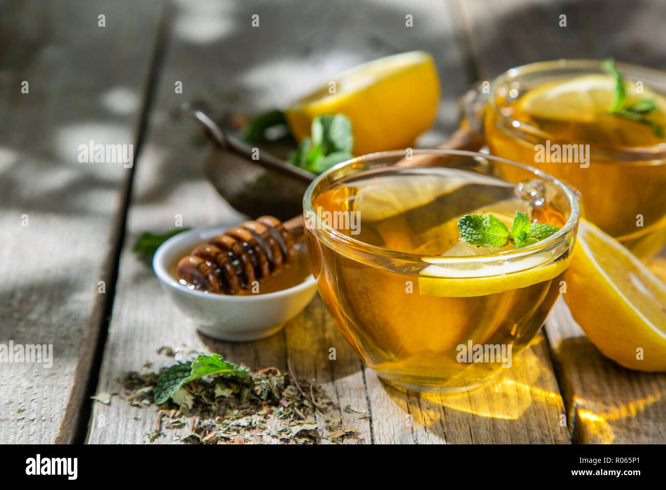 Summer tea - tea cups on rustic wood background with leaves shades ...