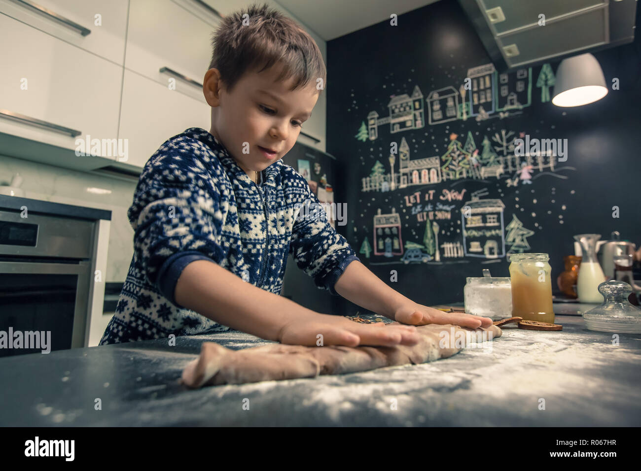 Happy Child cooking in the kitchen. Little boy helping mother to ...
