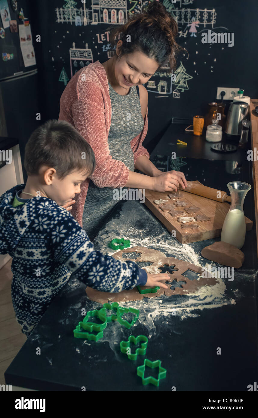 Happy Child cooking in the kitchen. Little boy helping mother to ...