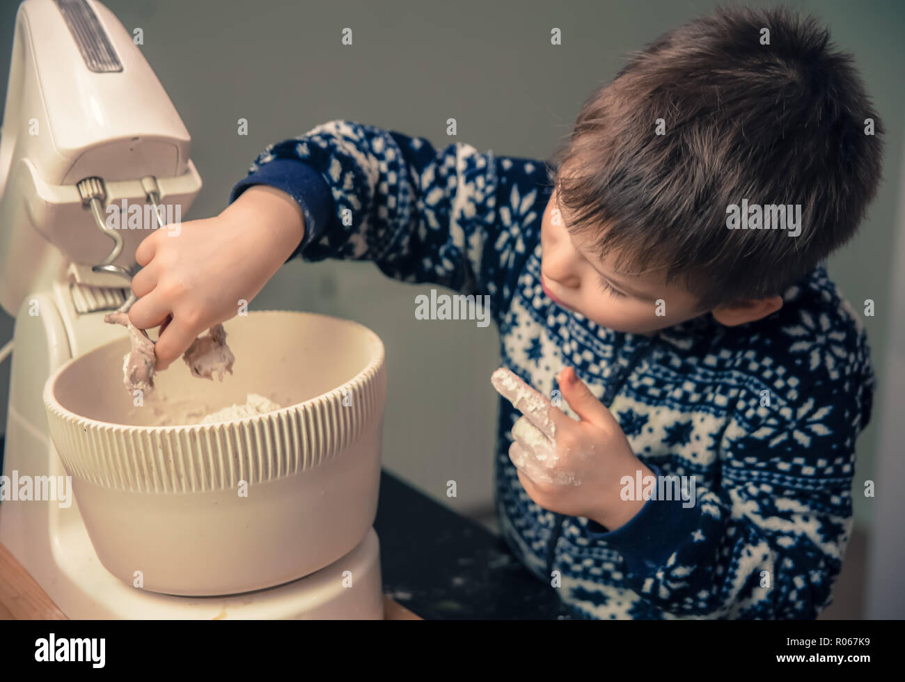 Happy Child cooking in the kitchen. Little boy helping mother to ...