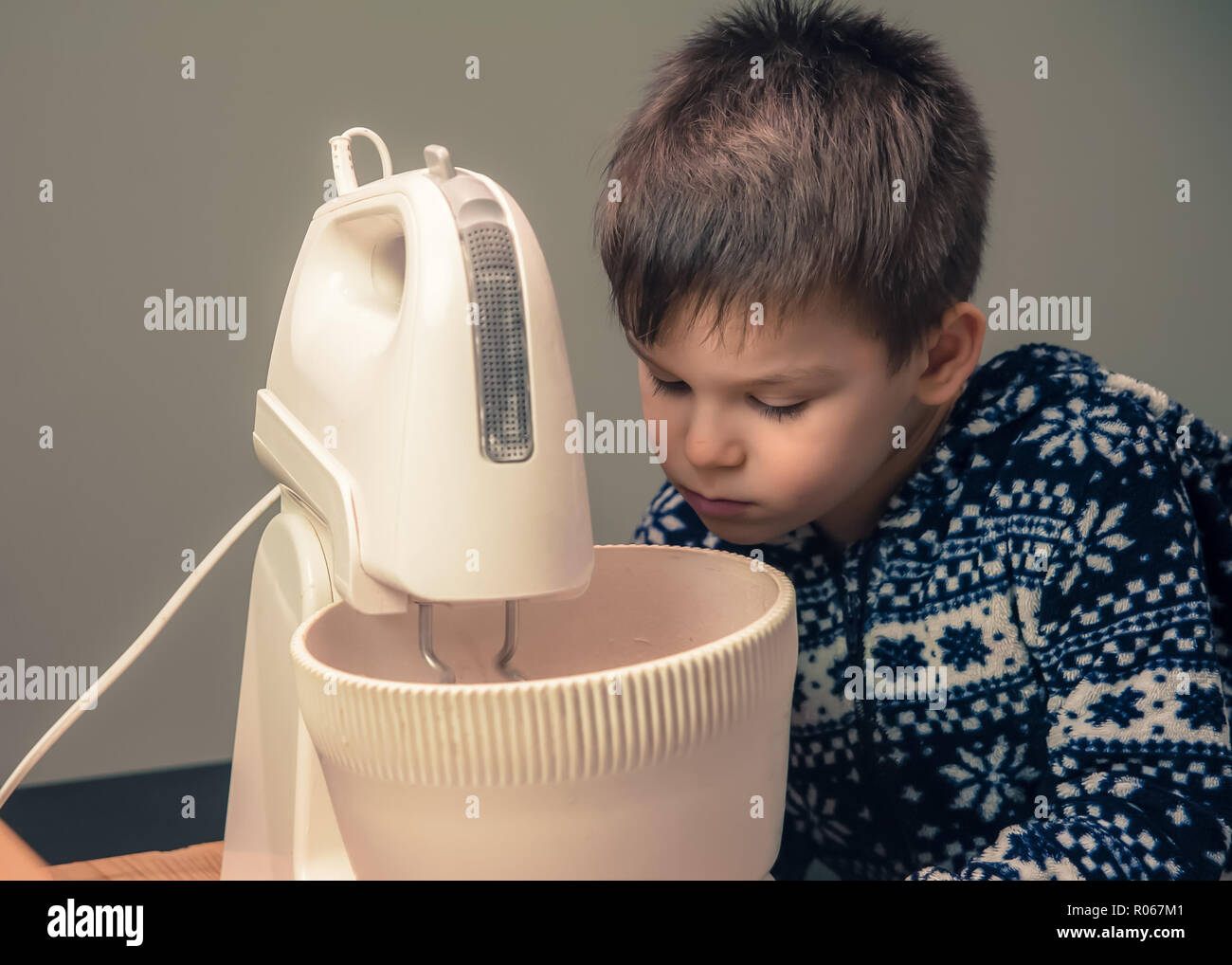 Happy Child cooking in the kitchen. Little boy helping mother to ...