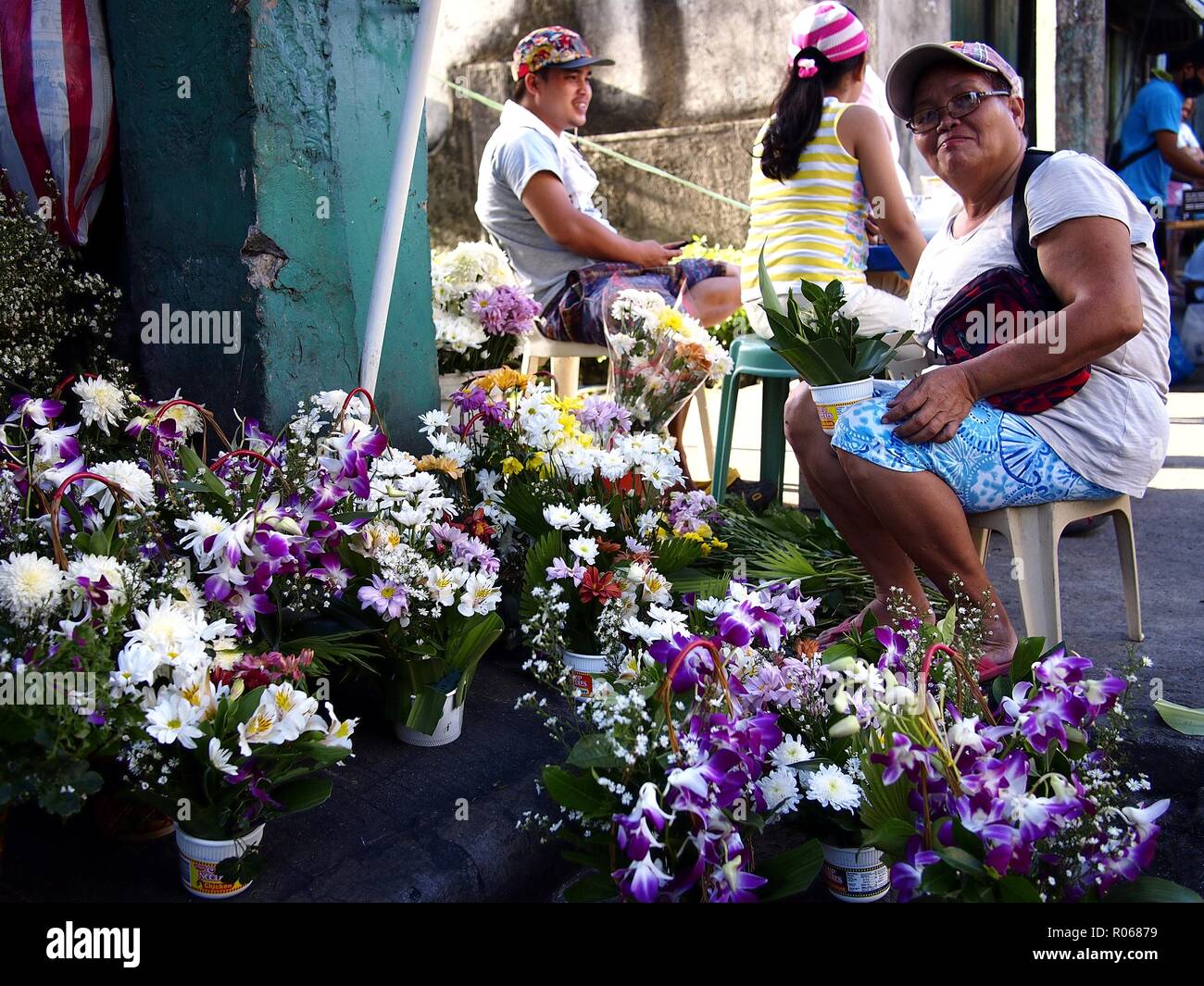 ANTIPOLO CITY, PHILIPPINES - OCTOBER 31, 2018: A vendor sells flowers ...