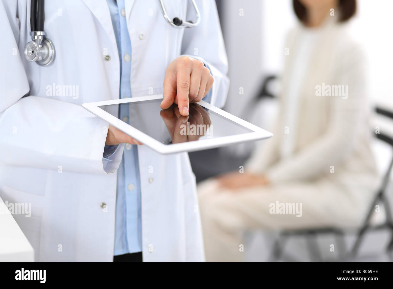 Female doctor woman using digital tablet while standing near reception ...