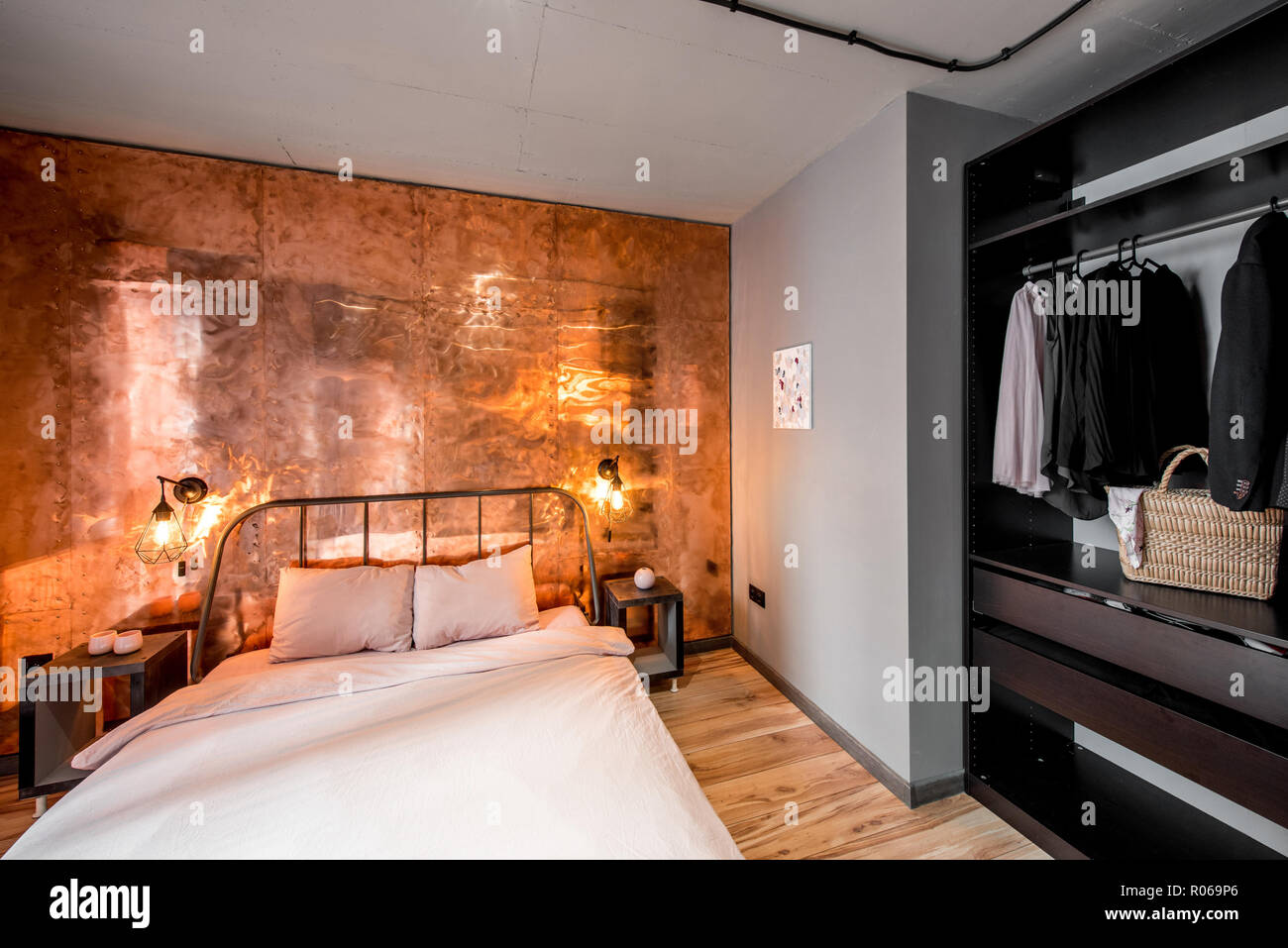 Modern loft bedroom interior with wall made of copper metal. Real ...