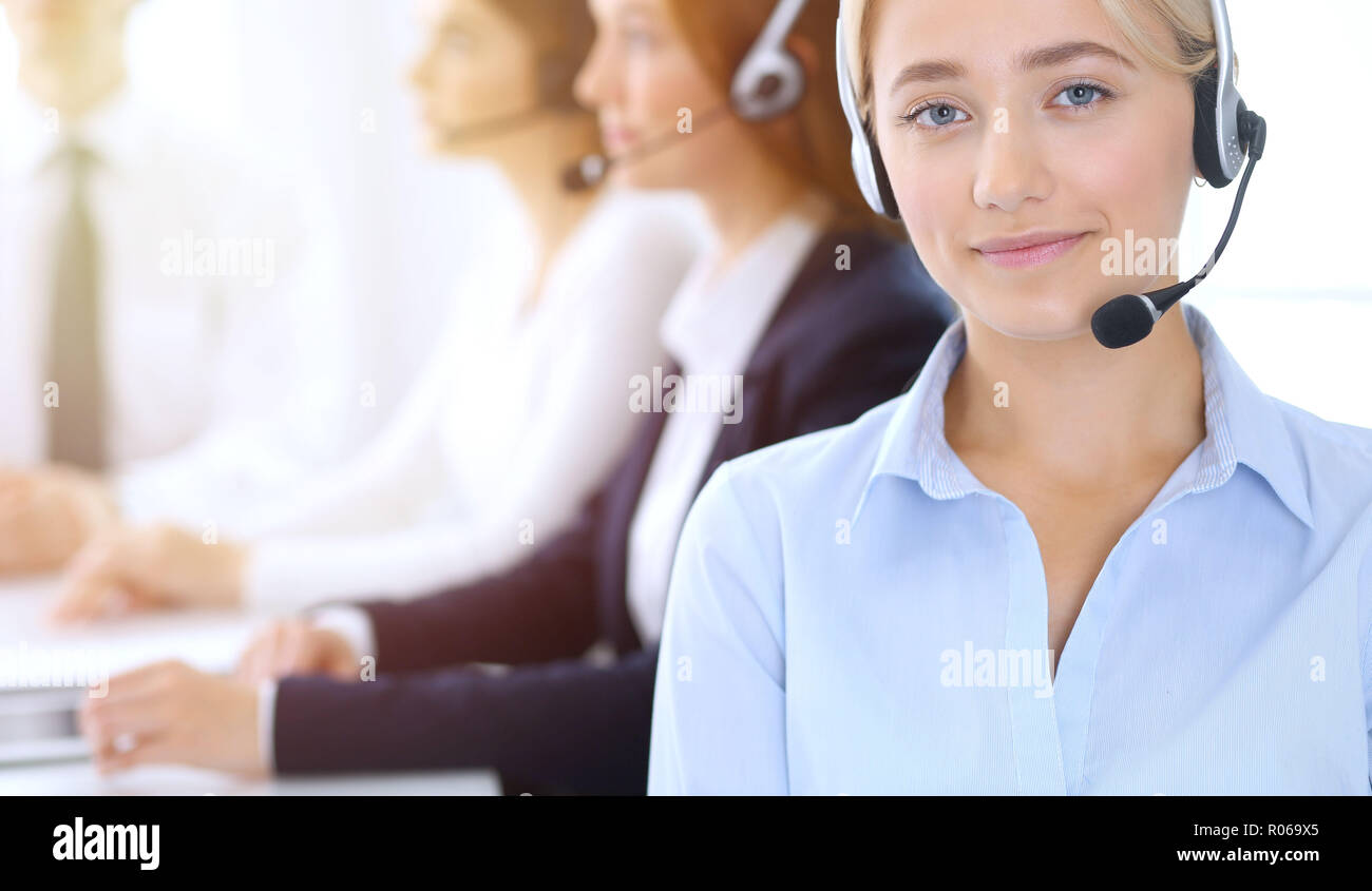 Call center. Group of operators at work. Focus at blonde business woman ...