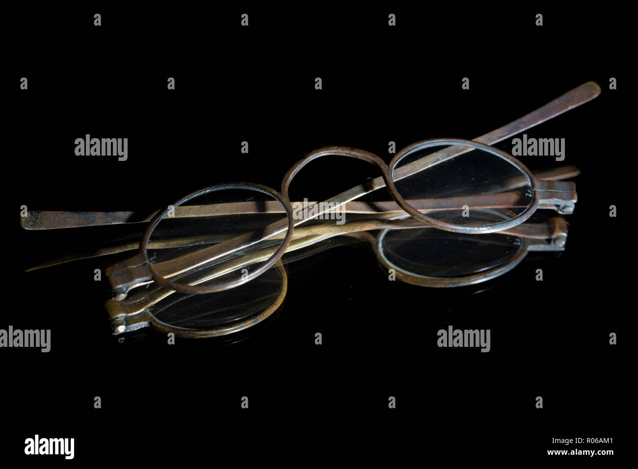 Closeup very old spectacles eyes glasses lying on mirror for reflection ...