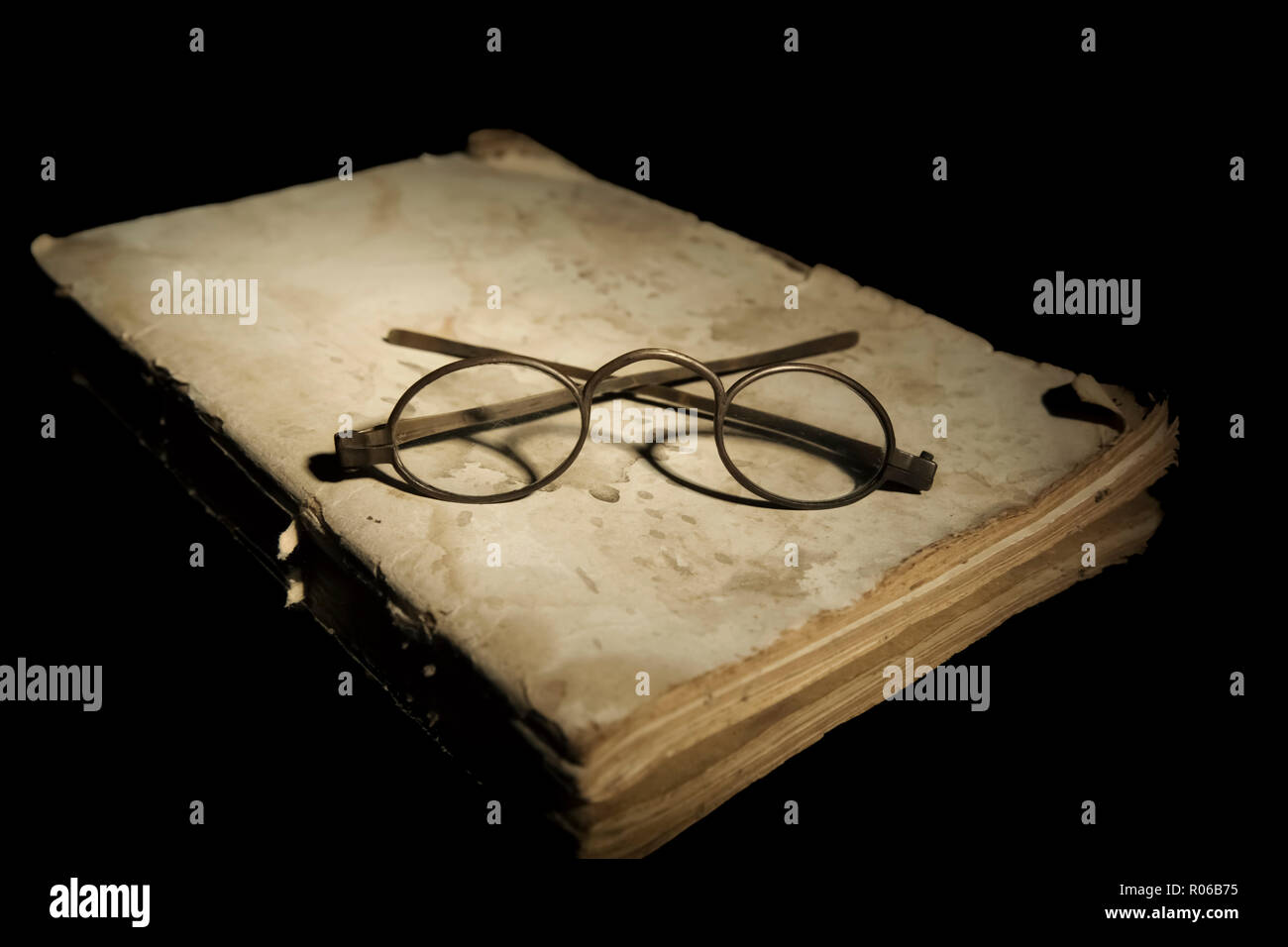 Closeup very old spectacles eyes glasseson very old closed book lying ...