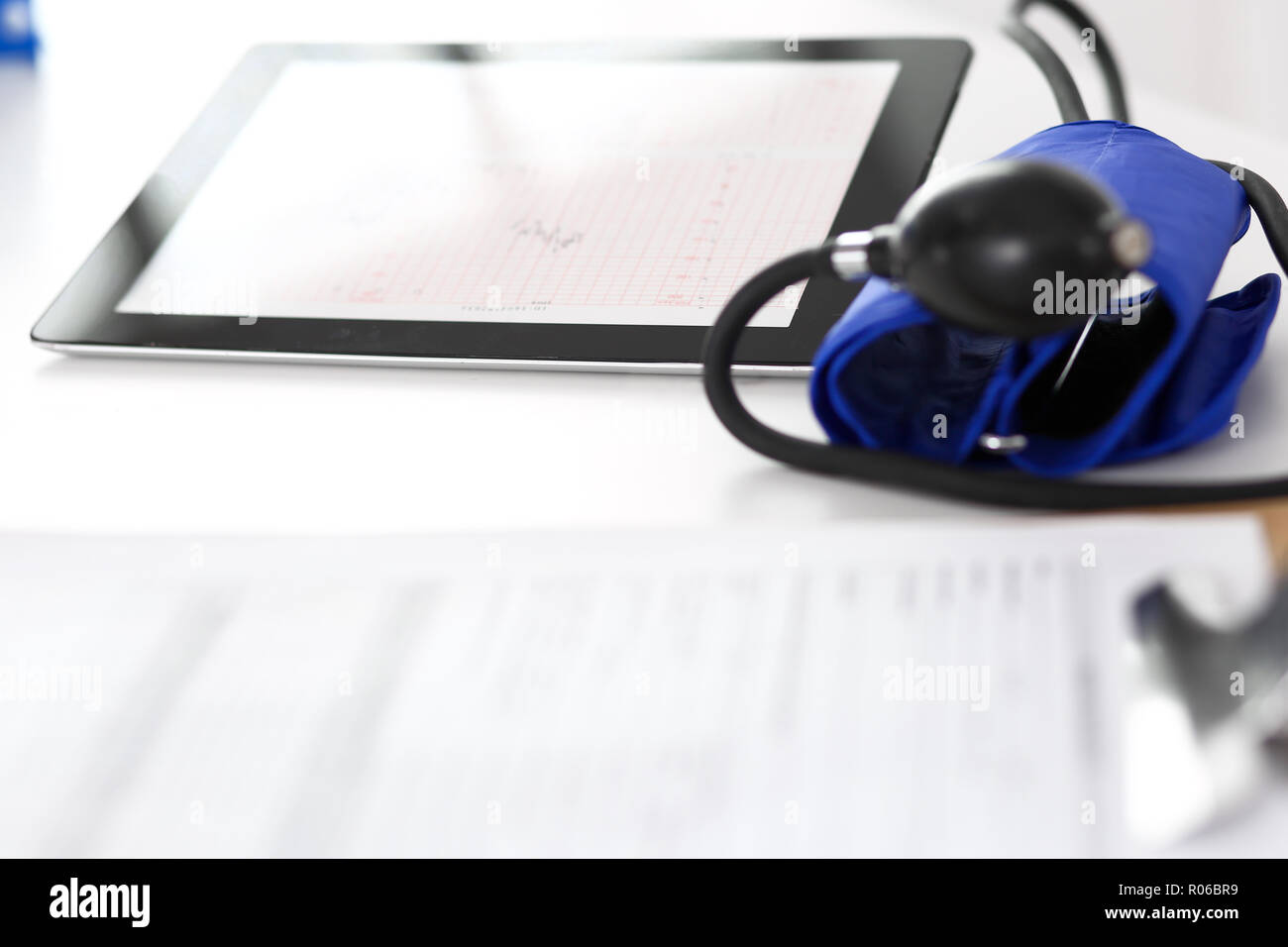 Workplace of doctor. Tablet ps showing heart diagrams closeup ...