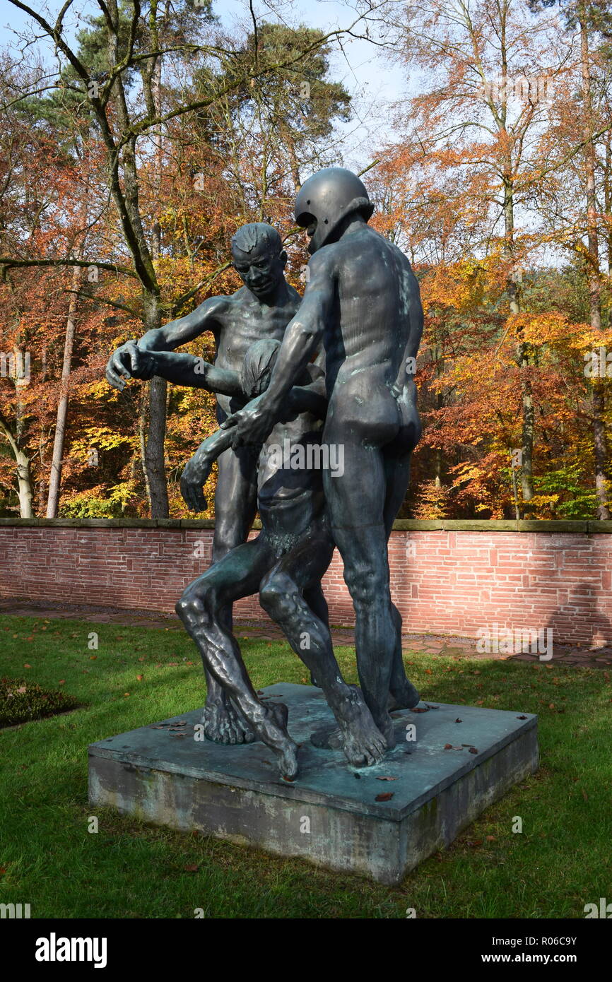 A bronze statue in Autumn in the War Cemetery in Reimsbach depicts two ...