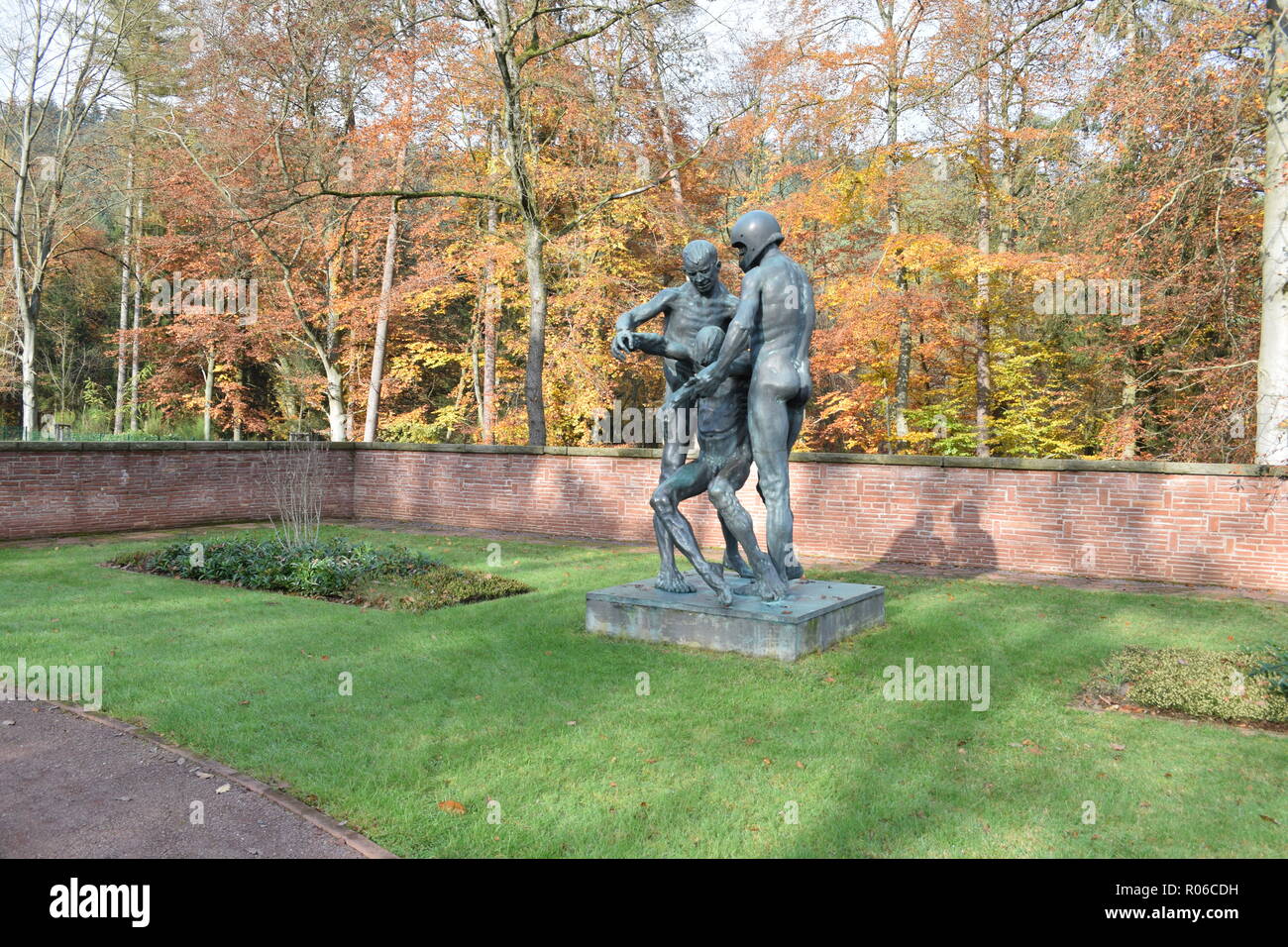 A bronze statue in Autumn in the War Cemetery in Reimsbach depicts two ...