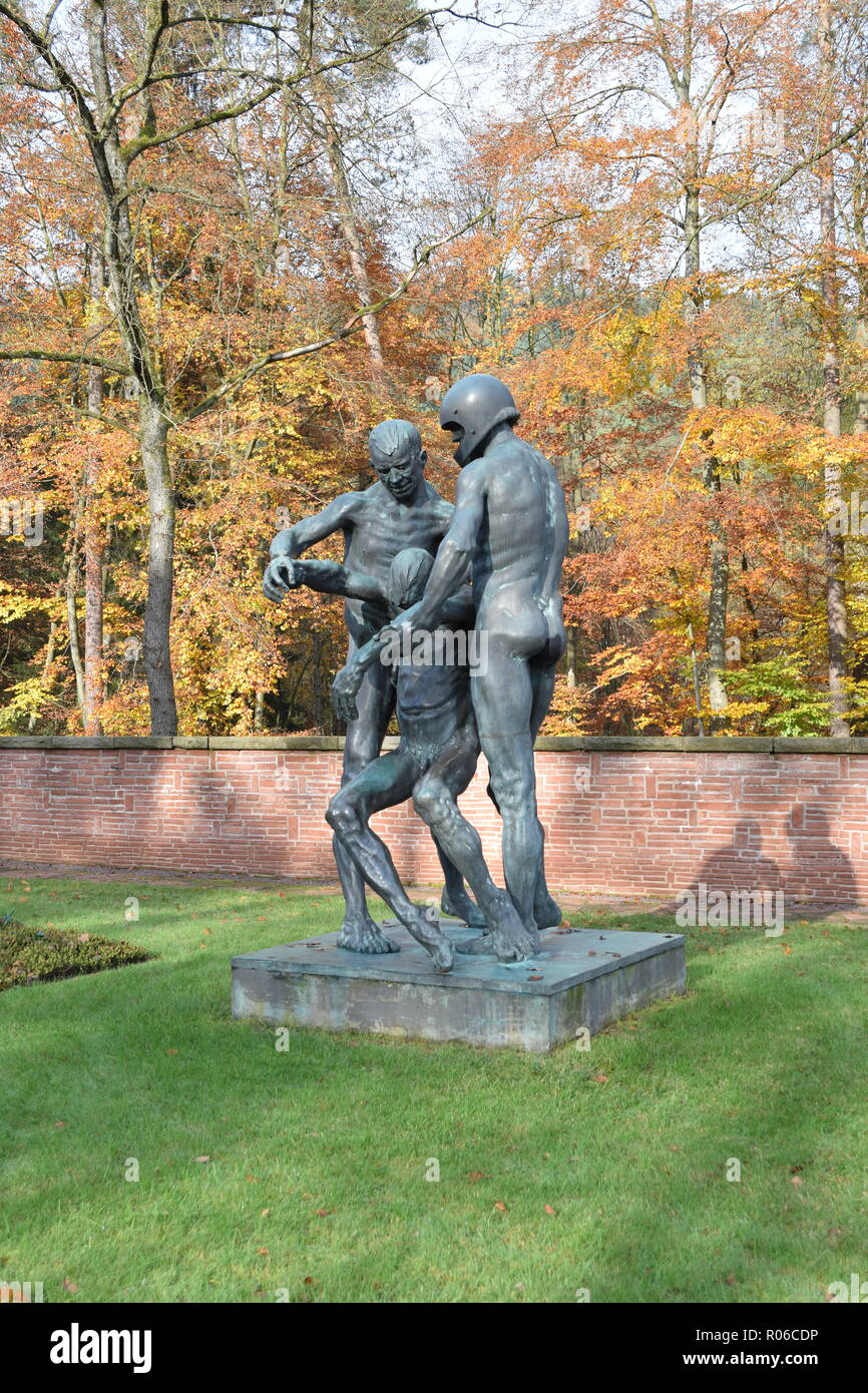 A bronze statue in Autumn in the War Cemetery in Reimsbach depicts two ...
