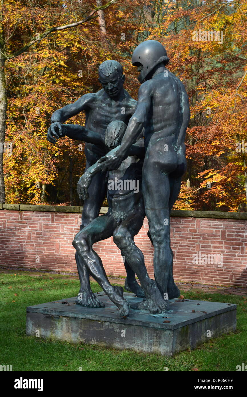 A bronze statue in Autumn in the War Cemetery in Reimsbach depicts two ...